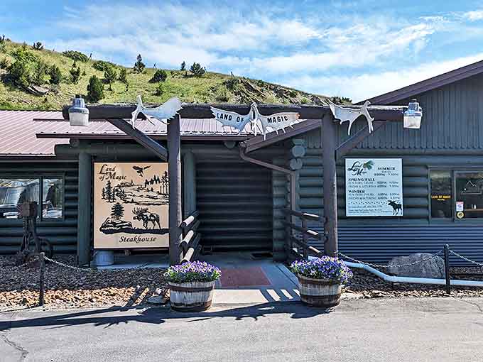 The entrance to The Land of Magic beckons like a frontier outpost for hungry travelers, complete with rustic wooden beams and Montana hillsides standing guard.