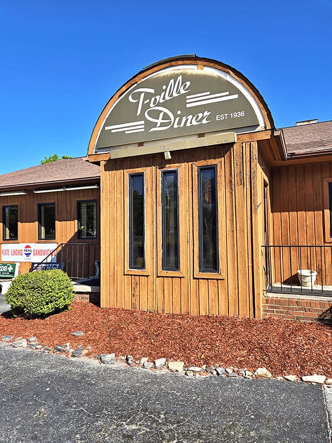 The iconic arched sign of T-Ville Diner stands proudly against a brilliant Carolina blue sky, promising comfort food that's stood the test of time.