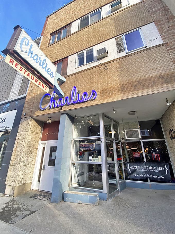 That iconic blue script sign beckons like an old friend on Minot's Main Street, promising comfort and satisfaction just steps away.