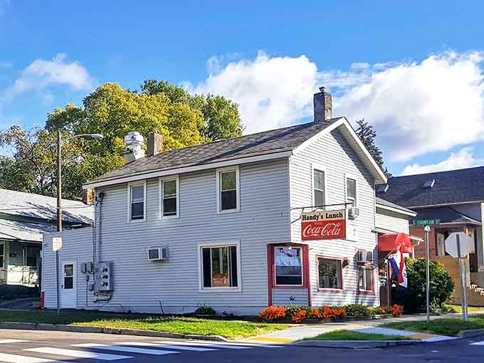 The classic white clapboard exterior of Handy's Lunch stands like a time capsule on the corner, complete with that iconic Coca-Cola sign beckoning hungry Vermonters inside.