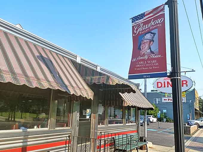 That iconic oval sign beckons like a lighthouse for hungry travelers. Angelo's stainless steel exterior and striped awnings are a portal to simpler, delicious times.