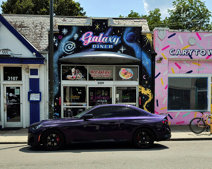 The cosmic facade of Galaxy Diner beckons hungry earthlings with its vibrant blue starscape and retro-futuristic signage. Breakfast served day or night&mdash;time is relative in space!
