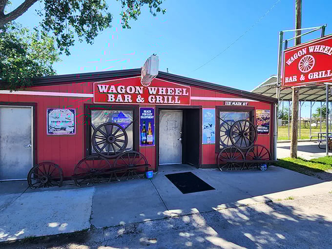 The bright red exterior of Wagon Wheel Bar & Grill stands as a beacon of hope for hungry travelers, complete with authentic wagon wheels that aren't just for show.