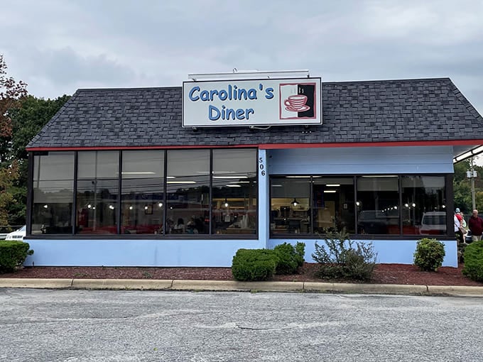 The blue and white exterior of Carolina's Diner stands as a beacon of hope for hungry travelers &ndash; a promise of honest food without pretension.
