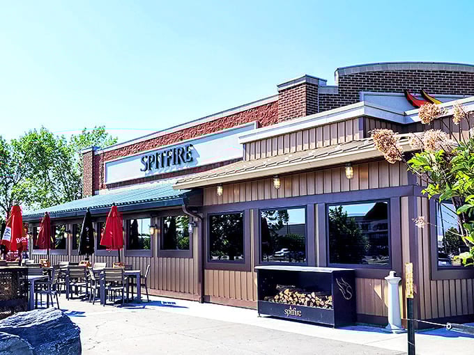 Brick, wood, and the promise of smoke &ndash; Spitfire's exterior hints at the primal cooking methods waiting inside. Those red umbrellas practically beckon you forward.