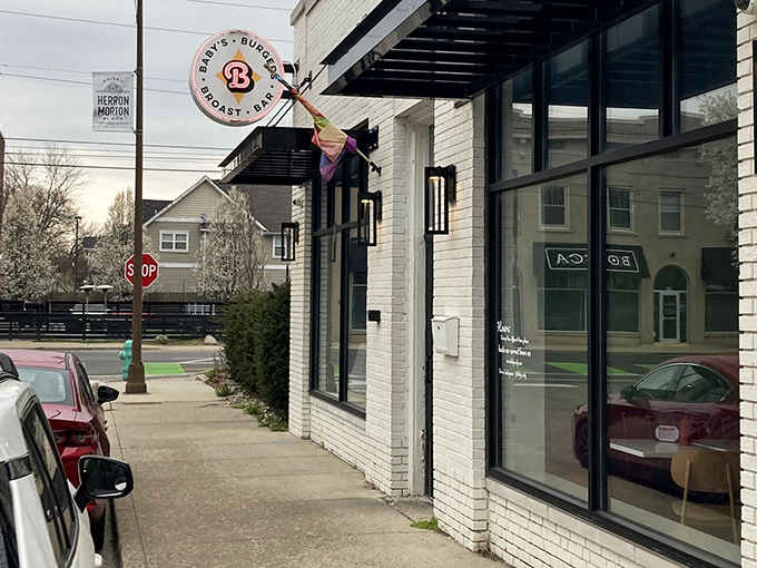 The iconic circular sign beckons hungry travelers like a retro lighthouse, promising burgers, broast, and bar delights in this charming Indianapolis neighborhood.