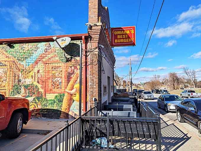 The unassuming brick exterior of Dinker's, complete with vibrant mural and bold "Omaha's Best Burger" sign, proves great food doesn't need fancy packaging.
