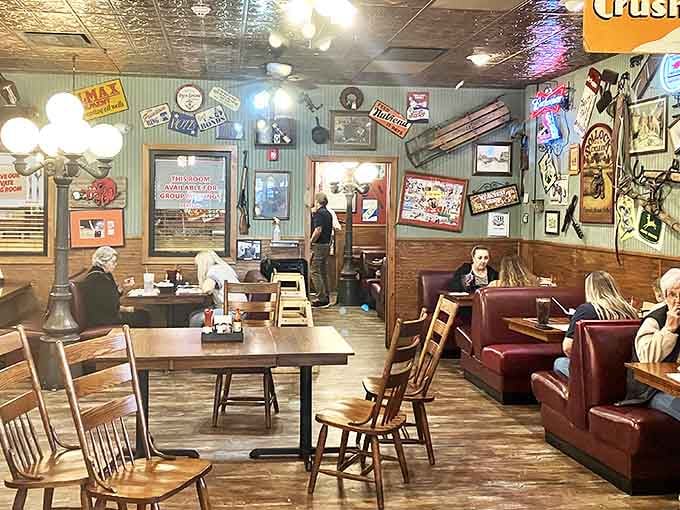 The dining room at Calico County feels like a time capsule of Americana, where vintage signs and warm lighting create the perfect backdrop for comfort food conversations.
