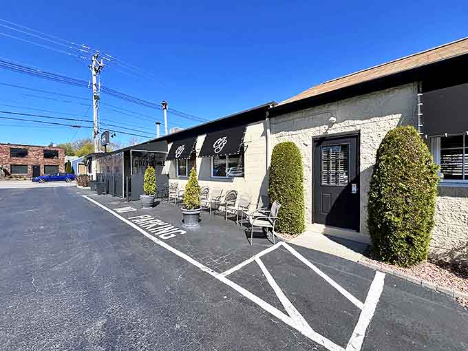 The unassuming exterior of The Cozy Grill, with its distinctive black awnings and neatly trimmed shrubs, belies the breakfast magic happening inside.