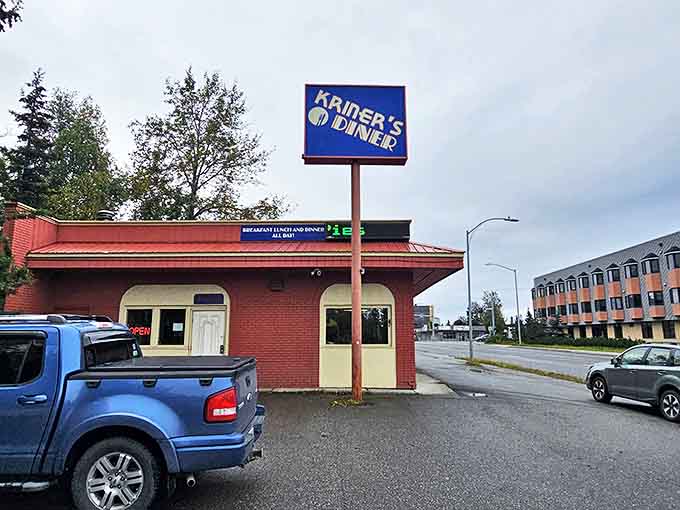 The bright blue sign of Kriner's Diner stands like a beacon of breakfast hope against Anchorage's sky, promising salvation for the hungry and caffeine-deprived.