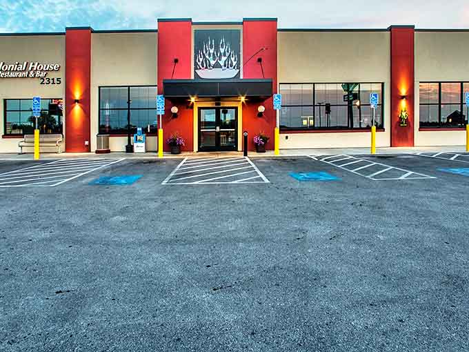 The vibrant red exterior of Colonial House Restaurant & Bar stands like a beacon of comfort food hope on Mount Rushmore Road, promising delicious rewards within.