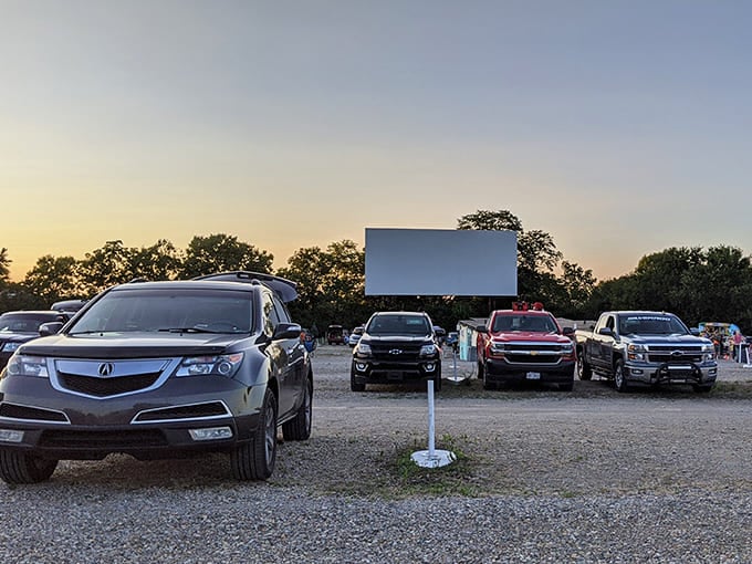 SUVs and trucks line up at dusk, parked in quiet anticipation in anticipation as the massive screen awaits its moment to shine against the fading Ohio sky.