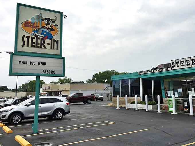 The classic Steer-In sign stands tall above the parking lot, featuring the restaurant's cartoon mascot and beckoning Indianapolis diners home.