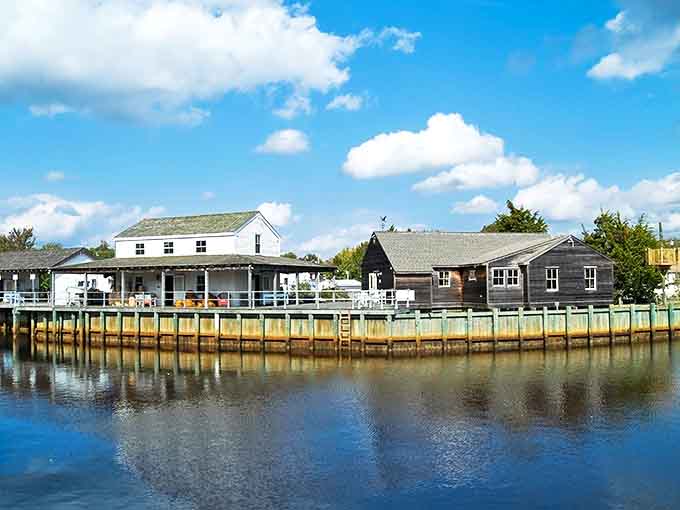 Historic waterfront buildings at Tuckerton Seaport reflect in the calm waters, creating a postcard-perfect scene that whispers stories of maritime heritage.