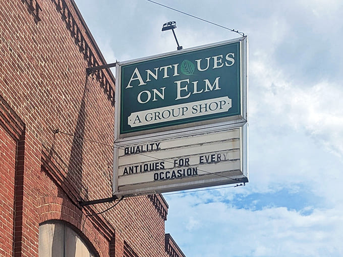 The iconic green sign of Antiques on Elm promises "Quality Antiques For Every Occasion" &ndash; because who doesn't need a special occasion antique?