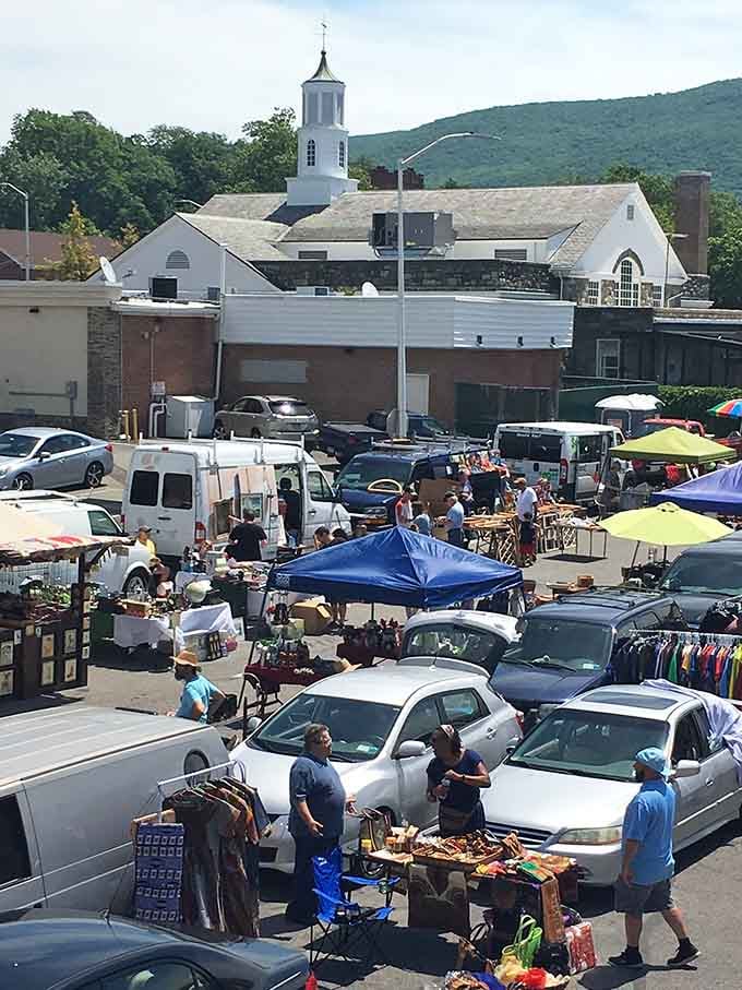 Church steeples and mountain views frame the market's organized chaos, where yesterday's discards become today's discoveries under the watchful gaze of Mount Beacon.