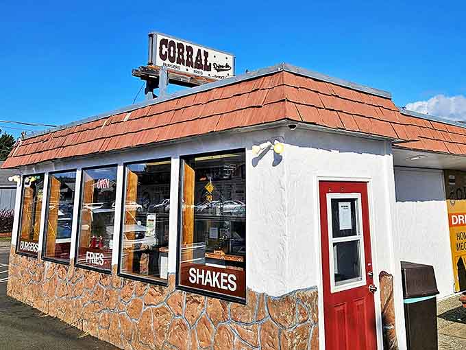 The Corral Drive In stands proudly against the Washington sky, its vintage sign and red-shingled roof beckoning hungry travelers like a culinary lighthouse on the coastal horizon.