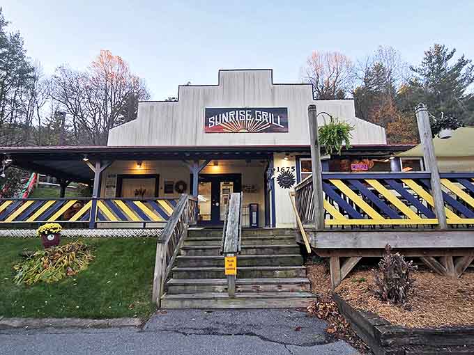 The stepped roofline of Sunrise Grill stands like a mountain range against the Carolina blue sky, promising breakfast adventures within those cheerful blue-and-yellow railings.