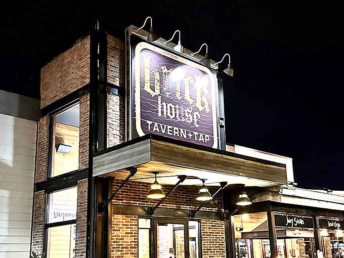 The warm glow of Brick House's iconic signage creates a welcoming beacon for those seeking unpretentious atmosphere and surprisingly delicious food.