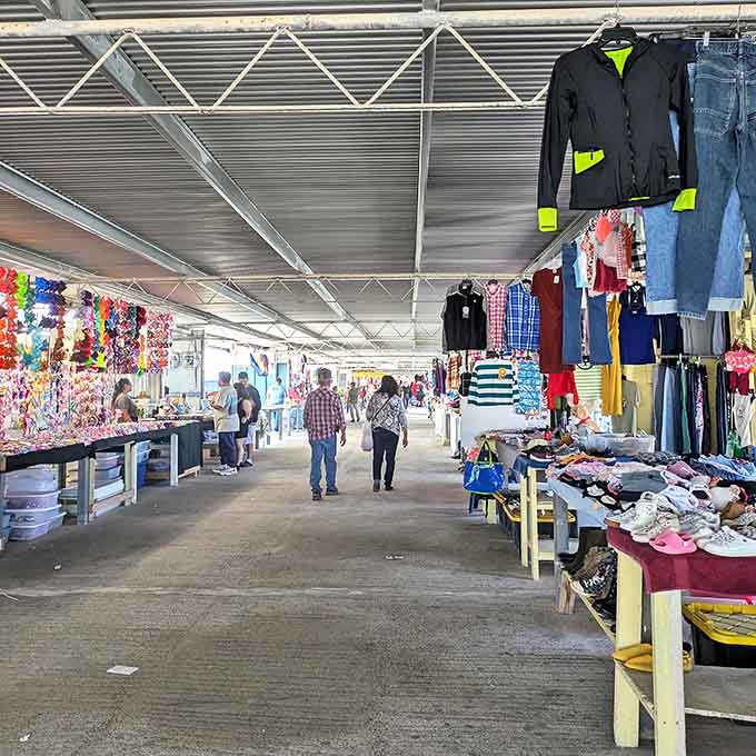 Shoppers stroll through the covered walkways of 77 Flea Market, where clothing vendors and trinket sellers create a bargain hunter's paradise.