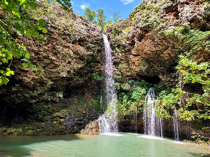 The 77-foot cascade of Dripping Springs Falls plunges into a turquoise pool, creating Oklahoma's own slice of paradise that feels straight out of a fantasy film.