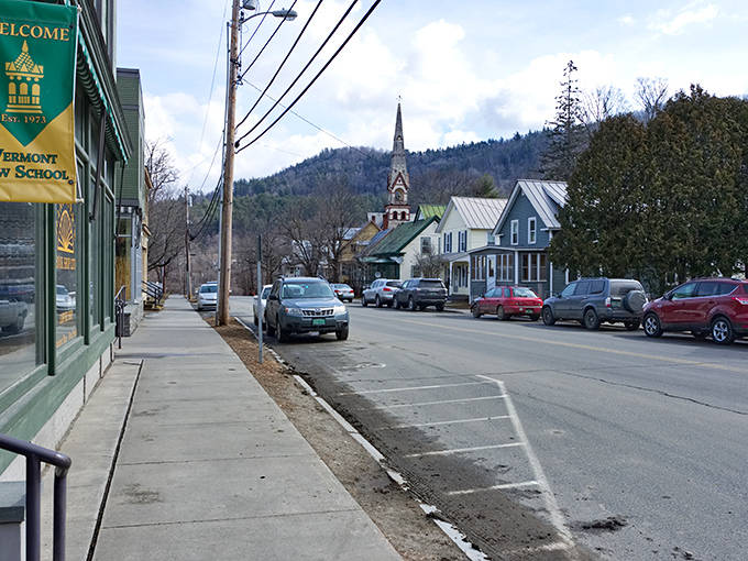 A glimpse down Chelsea Street reveals Vermont Law School's banner and the town's iconic church steeple, standing sentinel over this quintessential New England streetscape.