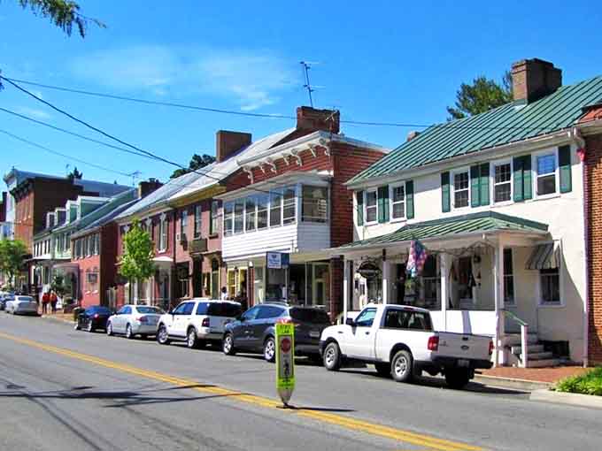 A perfect small-town tableau where green metal roofs crown buildings that have witnessed centuries of American history, all under that impossibly blue West Virginia sky.
