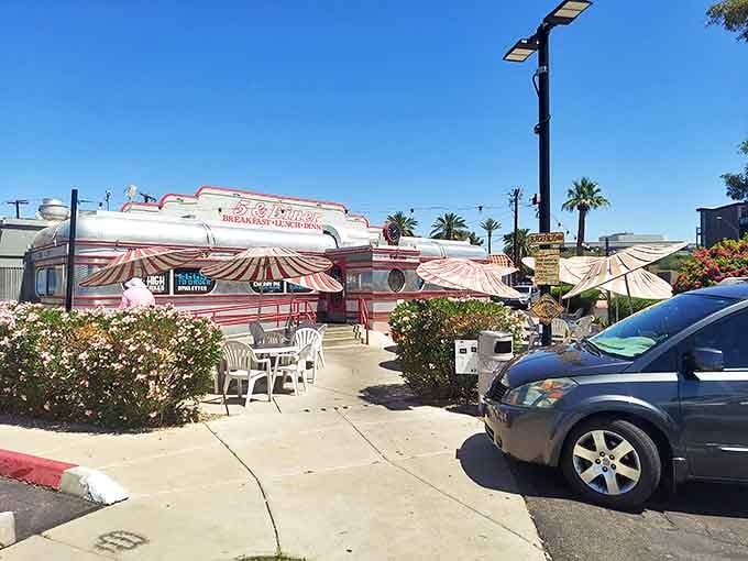 The gleaming silver exterior of 5 & Diner shines under the Arizona sun, its red-striped awnings inviting hungry patrons inside.