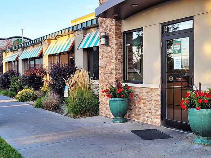 The distinctive orange roofline of Shellie's serves as a beacon for hungry locals and travelers alike, with those red bollards standing guard like sentinels protecting culinary treasure.