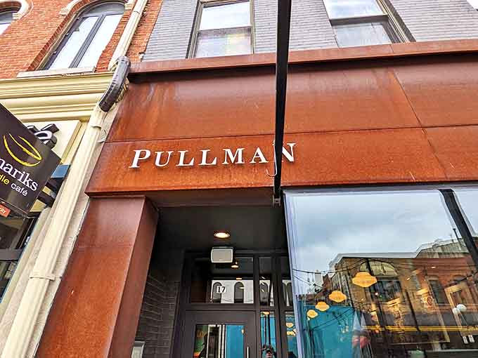 The rusty-hued exterior of Pullman beckons like a time machine to railway elegance, standing proudly among Iowa City's historic downtown buildings.