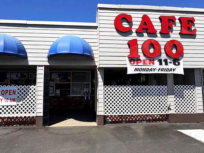 The unassuming exterior of Cafe 100 with its bright red signage and blue awnings—proof that culinary treasures often hide in plain sight.