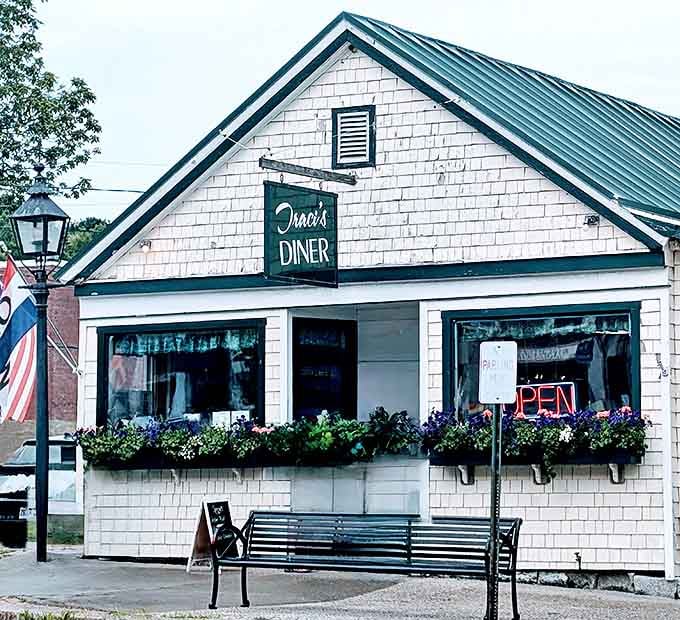 Summer flowers frame Traci's iconic green sign, a cheerful welcome that promises honest food and zero pretension &ndash; Maine hospitality in architectural form.