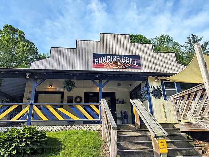 The stepped roofline of Sunrise Grill stands like a mountain range against the Carolina blue sky, promising breakfast adventures within those cheerful blue-and-yellow railings.