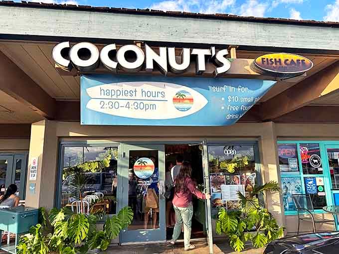 The surfboard sign says it all: "happiest hours" isn't just a promotion, it's a promise. Tropical plants stand guard at the entrance like leafy bouncers with good vibes.