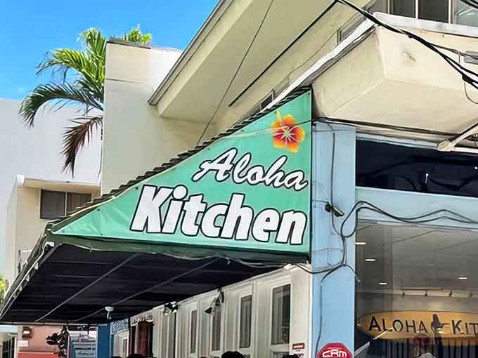 Aloha Kitchen's vibrant green awning welcomes hungry patrons to this beloved Honolulu breakfast spot under clear blue Hawaiian skies.