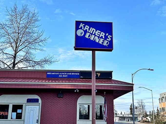 Even in winter's grip, Kriner's vibrant sign stands out against Alaska's blue sky, a colorful promise of warmth and comfort food waiting inside.