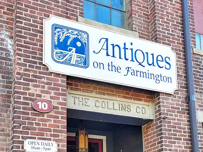 The historic brick fa&ccedil;ade of Antiques on the Farmington welcomes treasure hunters with its classic blue and white sign, promising adventures in time travel without the jetlag.