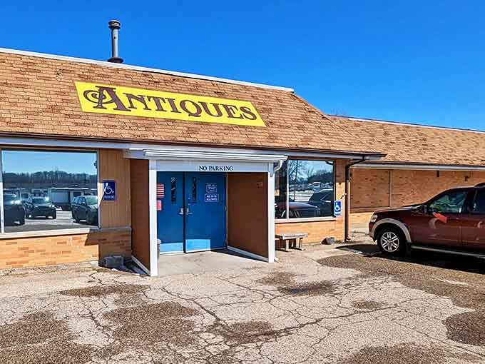The iconic yellow "ANTIQUES" sign welcomes treasure hunters to Great Lakes Antique Mall's inviting brick exterior in Coloma, Michigan.
