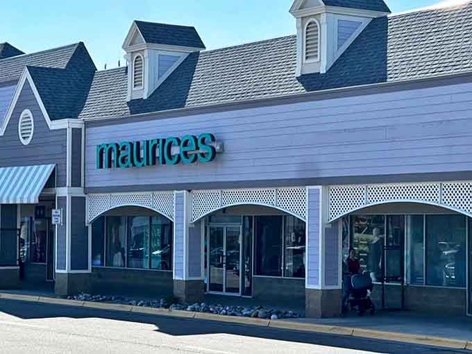 Maurices showcases its distinctive teal signage against the outlet's signature blue-gray clapboard, offering fashion finds that won't send your credit card into therapy.