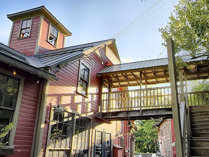 Sunlight plays across the weathered clapboard and wooden walkways, creating the perfect setting for an afternoon of literary treasure hunting and riverside contemplation.