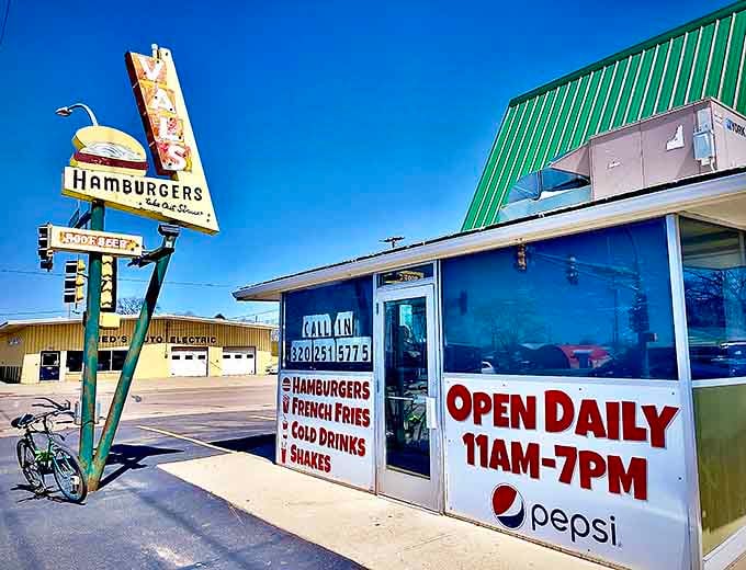 That iconic yellow sign has been beckoning hungry travelers to Val's for decades, promising burger perfection under that distinctive A-frame roof.