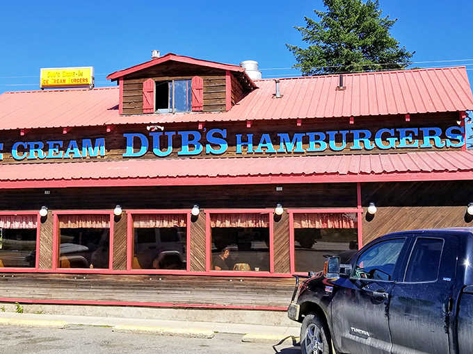 The rustic wooden exterior of Dub's Drive-In, with its signature red trim and picnic tables, stands as a time capsule of Americana in Sandpoint.