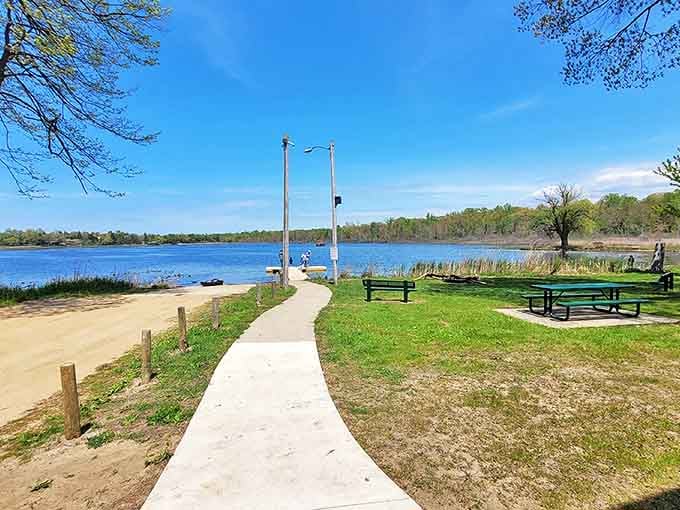 A perfect picnic spot where nature provides both the view and the seating arrangement. Lake, bench, and blue skies&mdash;Michigan's version of waterfront property.
