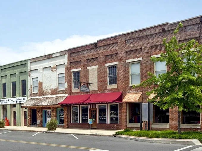 Historic brick storefronts line Tuscumbia's charming downtown, where colorful awnings welcome visitors to locally-owned shops and eateries.