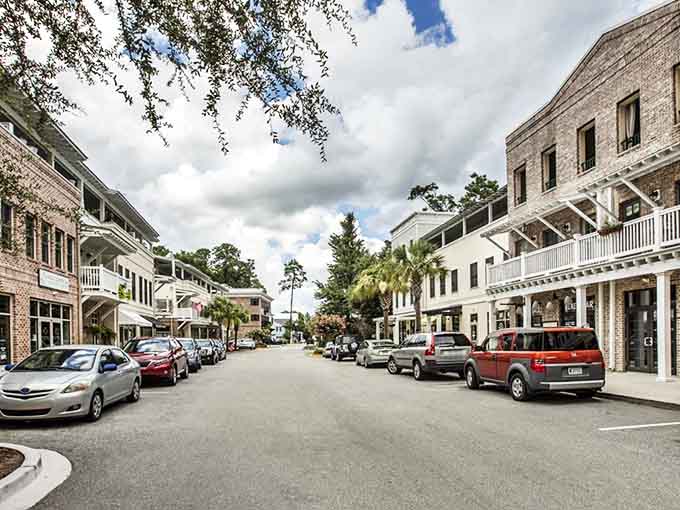 Brick facades and white balconies create Bluffton's distinctive architectural character in the heart of Old Town's shopping district.