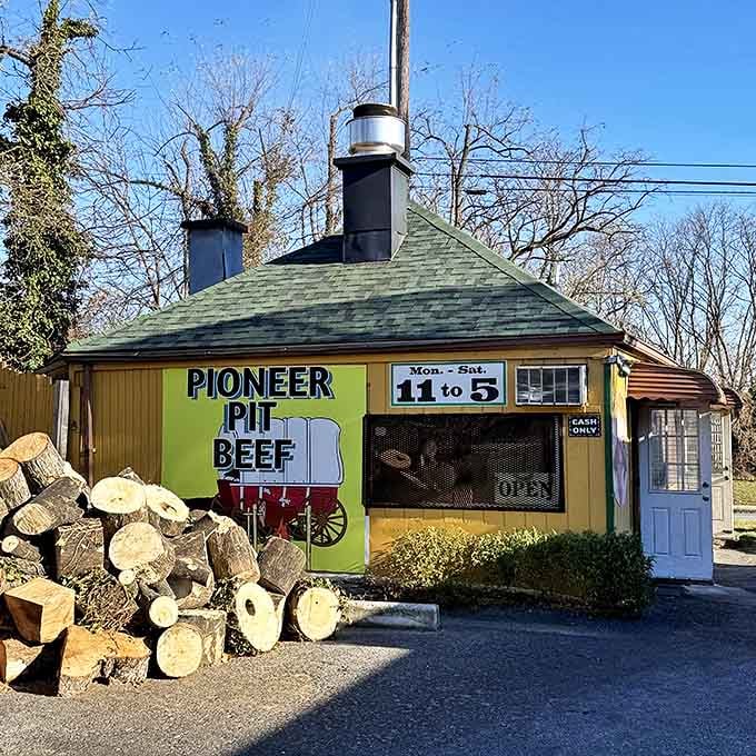 Stacked firewood beside Pioneer Pit Beef's humble exterior reveals the secret to their authentic flavor&mdash;real wood for that perfect char.