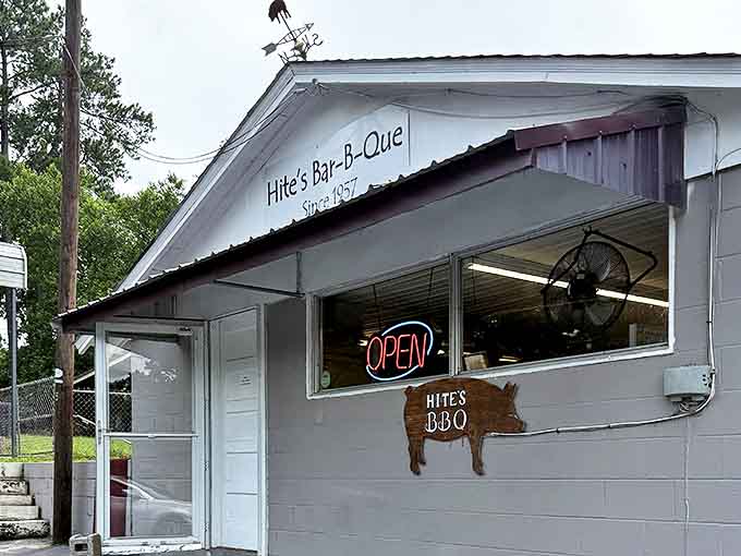 The unassuming white exterior of Hite's might fool you, but that wooden pig sign? That's the beacon of barbecue bliss calling your name.