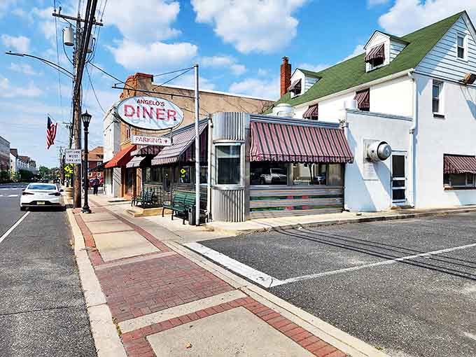 That iconic oval sign beckons like a lighthouse for hungry travelers. Angelo's stainless steel exterior and striped awnings are a portal to simpler, delicious times.
