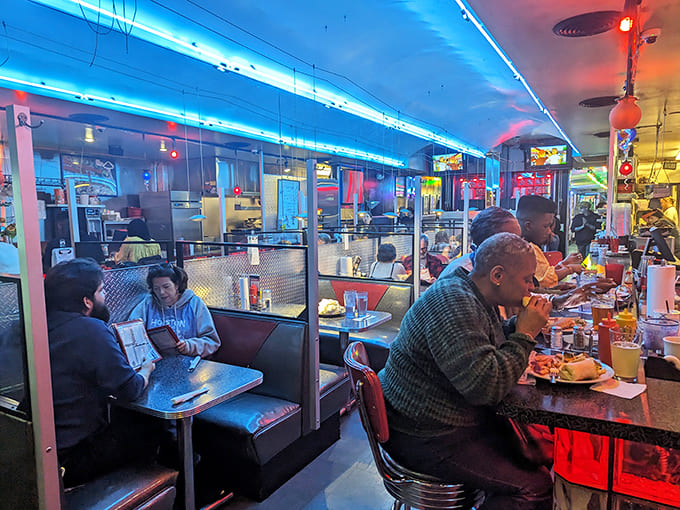 The cosmic facade of Galaxy Diner beckons hungry earthlings with its vibrant blue starscape and retro-futuristic signage. Breakfast served day or night&mdash;time is relative in space!