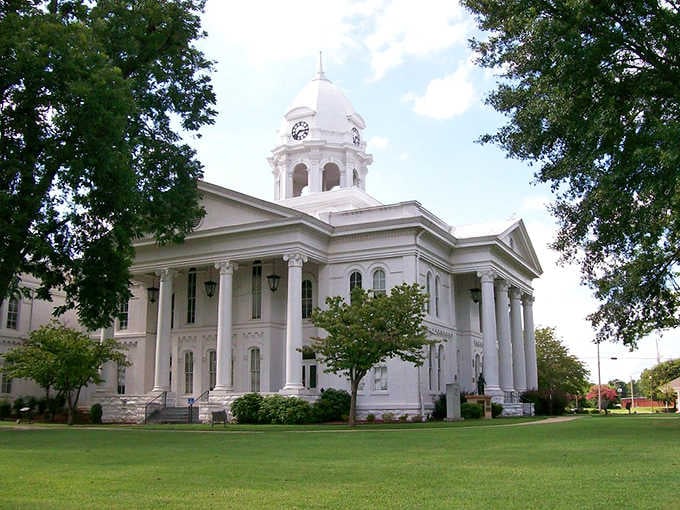 The majestic Colbert County Courthouse stands proudly with its gleaming white columns and elegant dome, surrounded by lush green lawns.